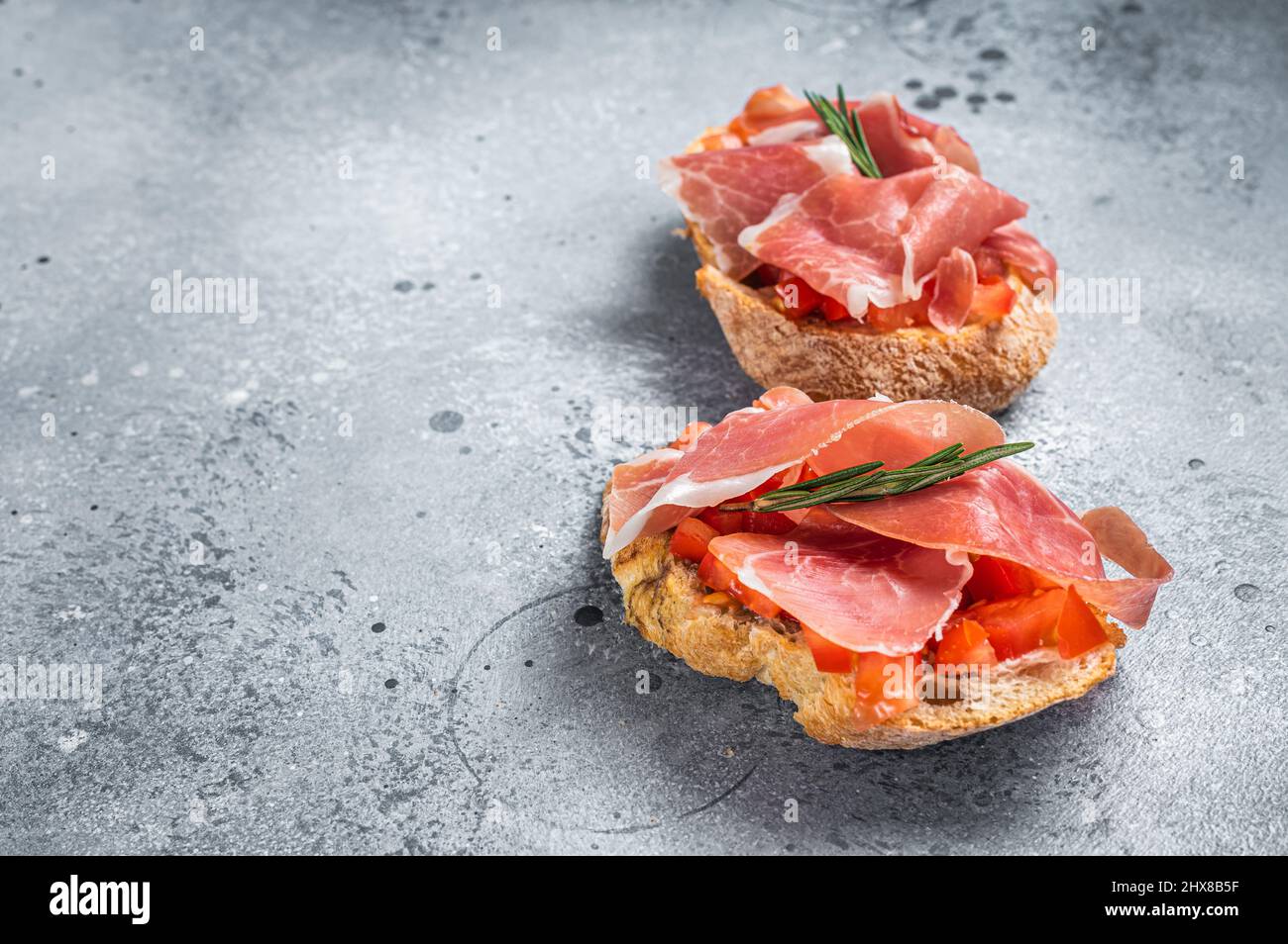 Spanish Tapas with tomatoes and cured Slices of jamon iberico ham ...