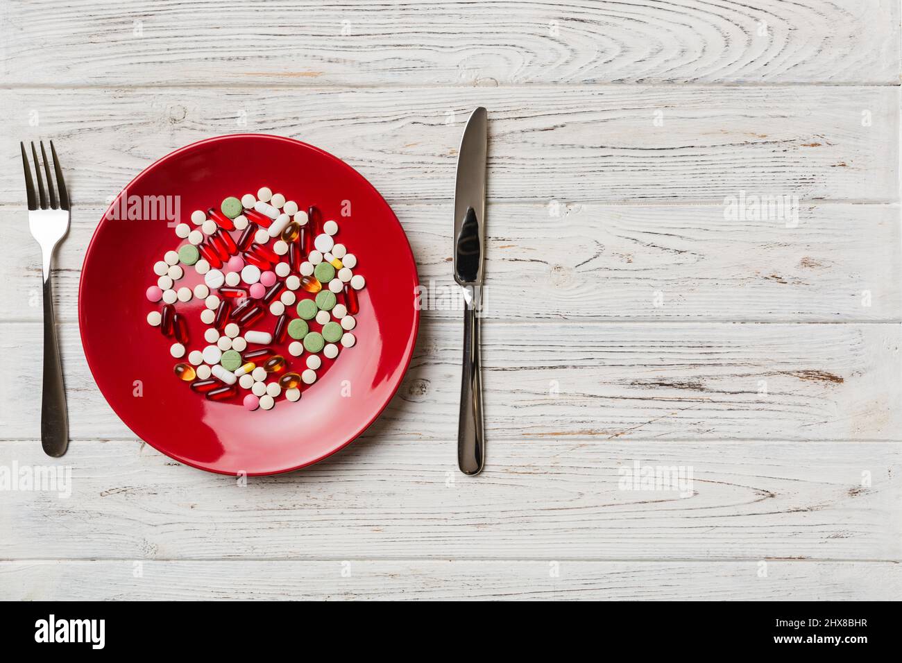 Many different weight loss pills and supplements as food on round plate ...