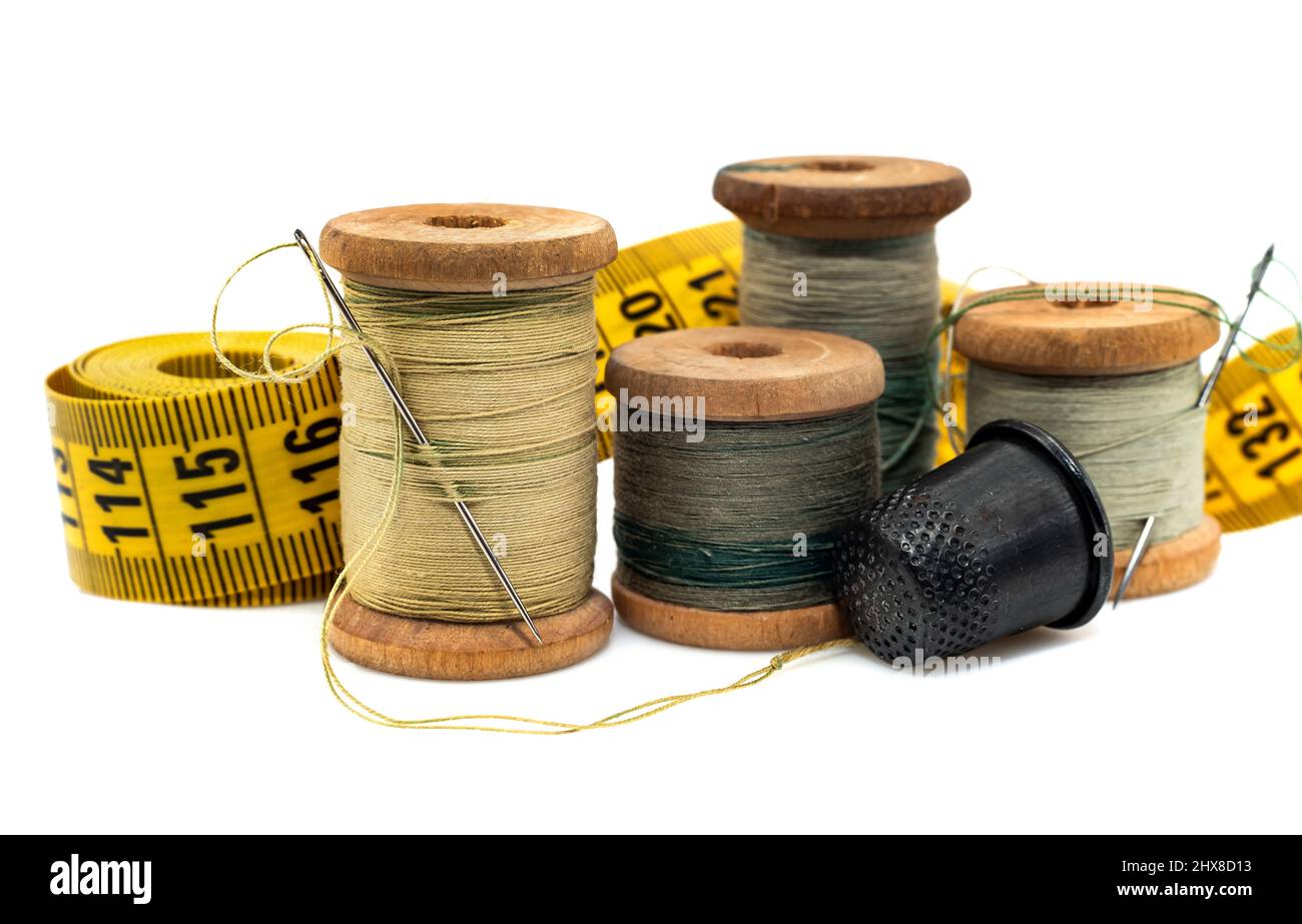 Spools of colored threads, a thimble and a sewing tape measure on a ...