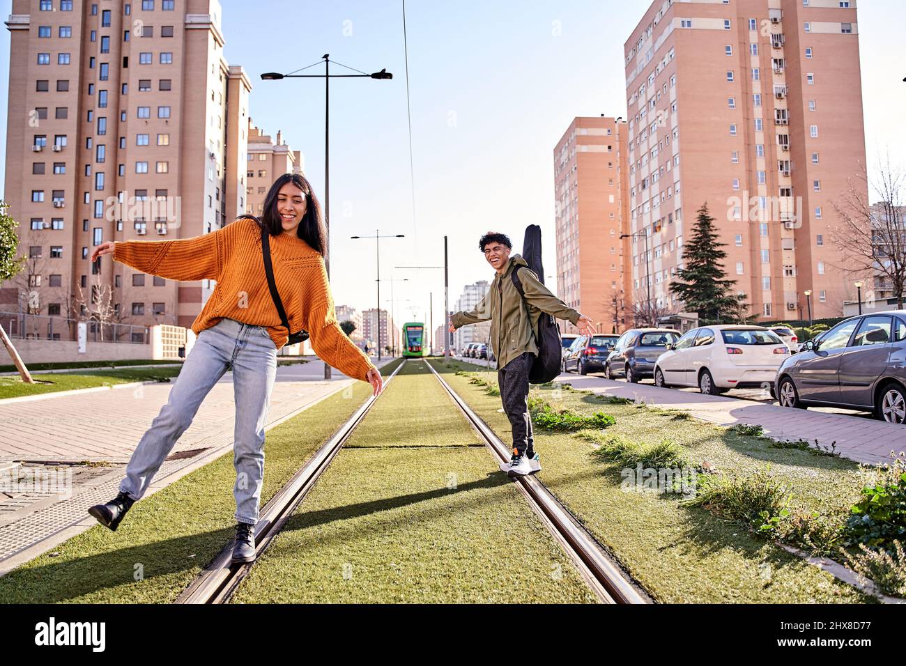 couple balancing on the train or tram tracks while laughing. youth and ...
