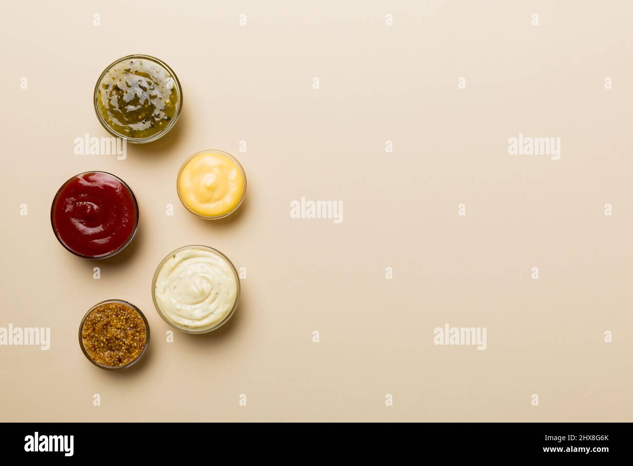 Different types of sauces in bowls on a colored Board . Top view ...