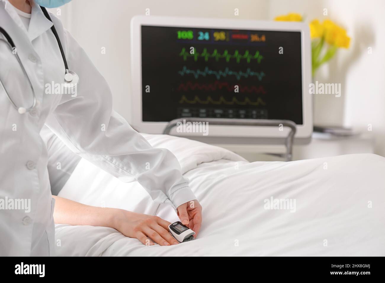 Doctor measuring oxygen saturation level of patient's blood in clinic ...