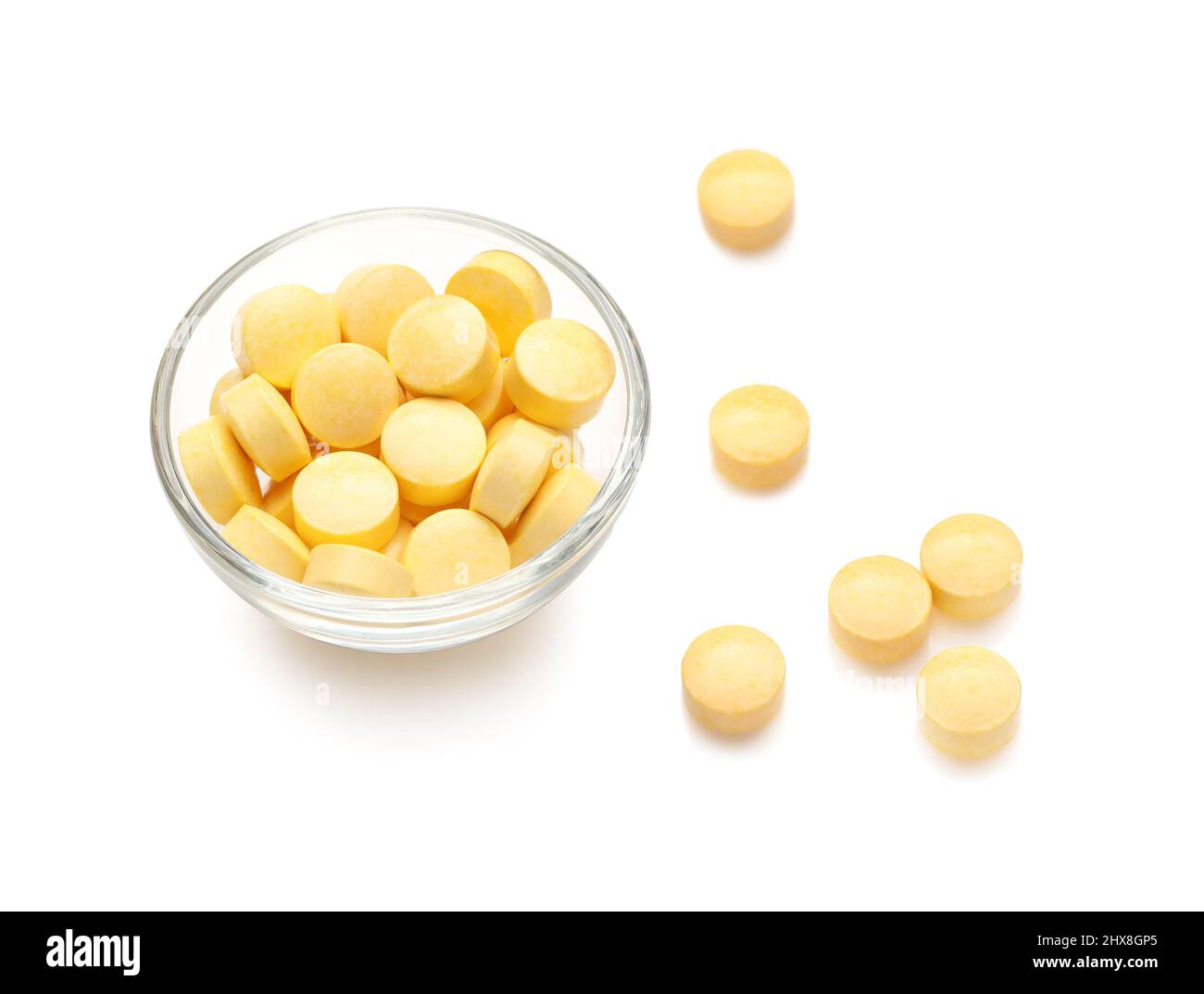 Bowl with yellow pills on white background Stock Photo - Alamy