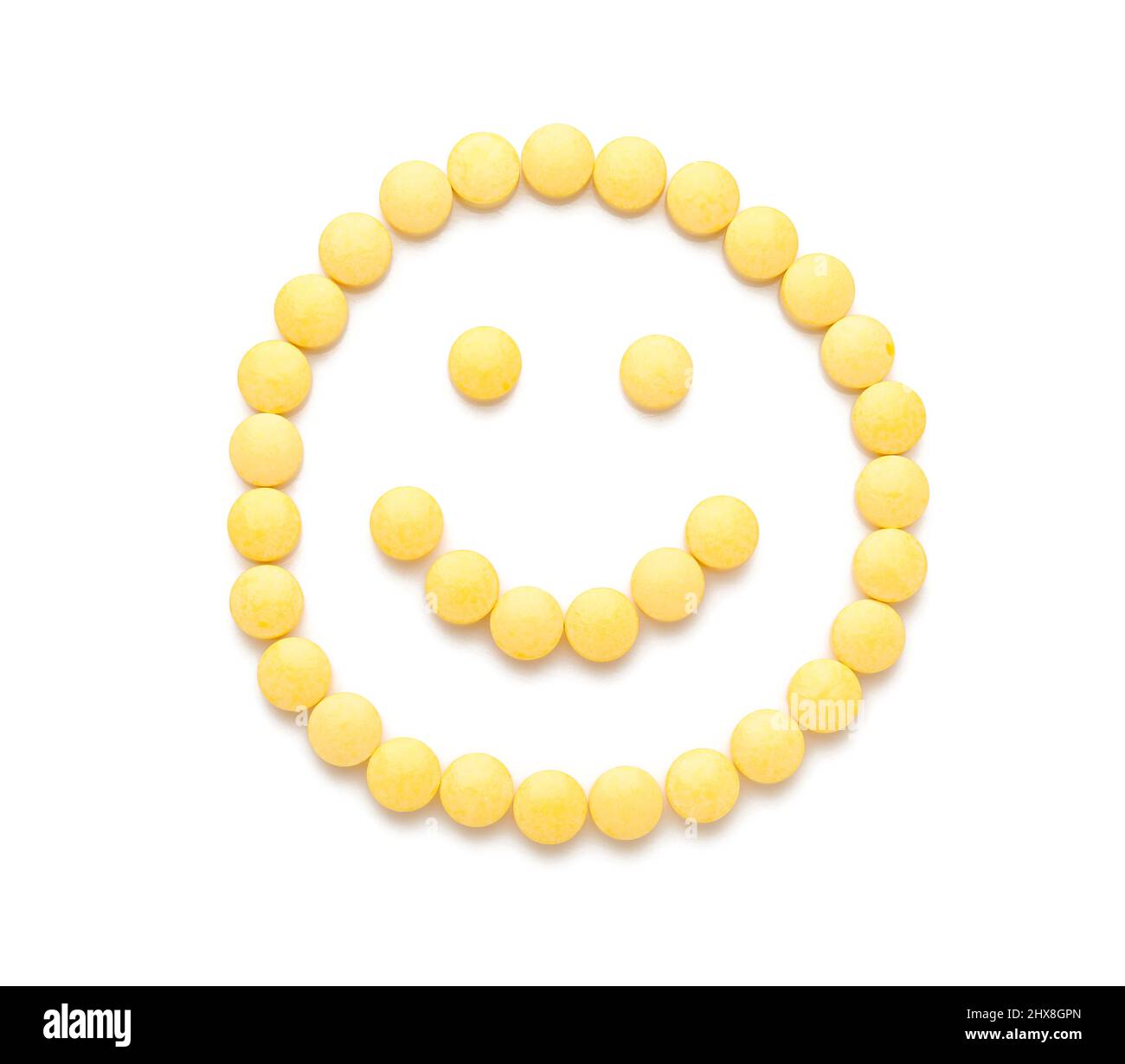 Happy smiley made of yellow pills on white background Stock Photo - Alamy