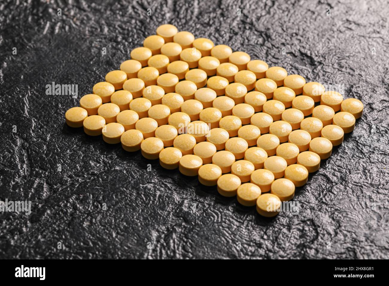 Yellow pills on dark background Stock Photo - Alamy