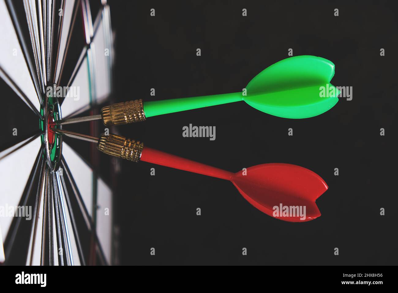 Two darts are stuck in the center of dartboard.Achieving goals in business and in life Stock ...