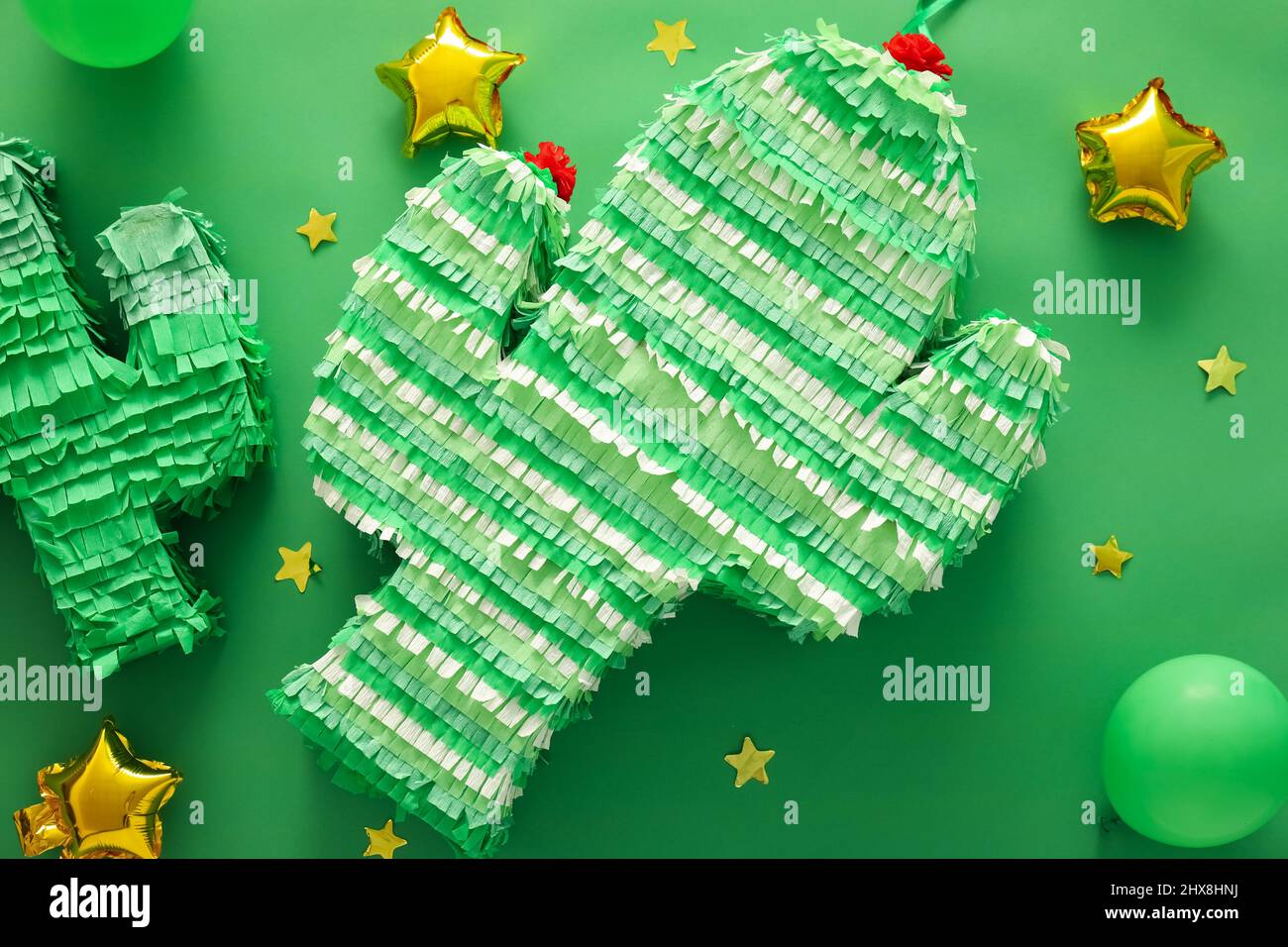 Mexican pinatas and balloons on green background Stock Photo - Alamy