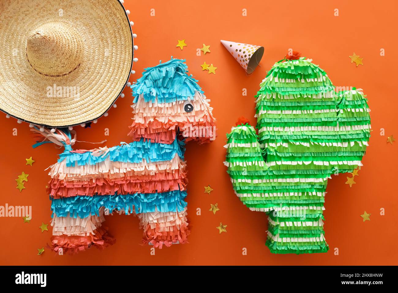 Mexican pinatas and sombrero hat on color background Stock Photo - Alamy