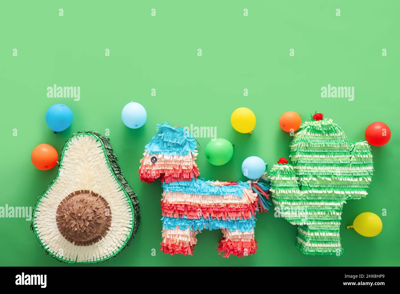 Different Mexican pinatas with balloons on green background Stock Photo ...