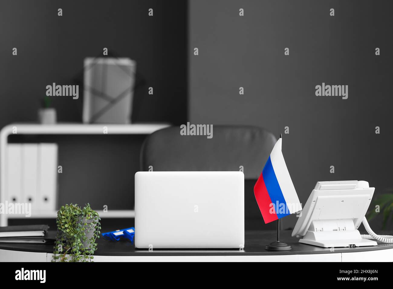 Workplace with Russian flag, modern laptop, houseplant and landline ...