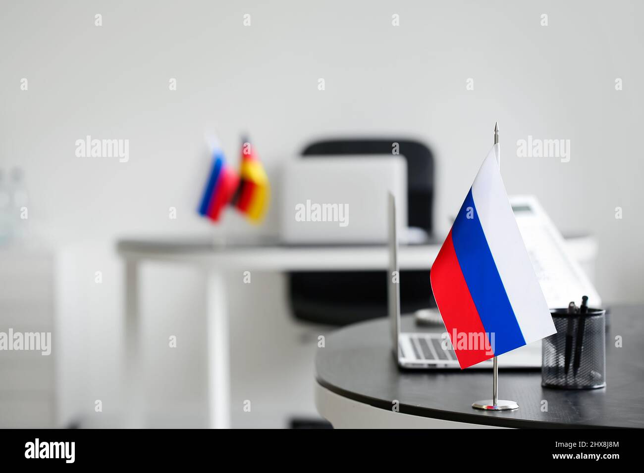 Russian flag, stationery holder and laptop on table in office Stock ...