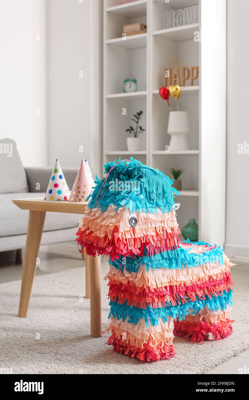 Mexican pinata and table with party hats in living room Stock Photo - Alamy