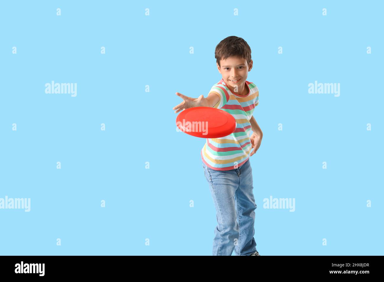 Funny little boy playing frisbee on color background Stock Photo - Alamy