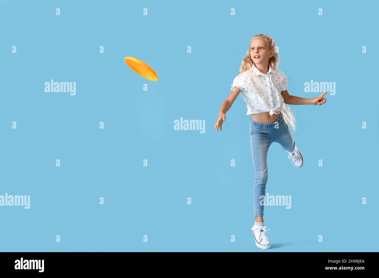 Funny little girl playing frisbee on color background Stock Photo - Alamy