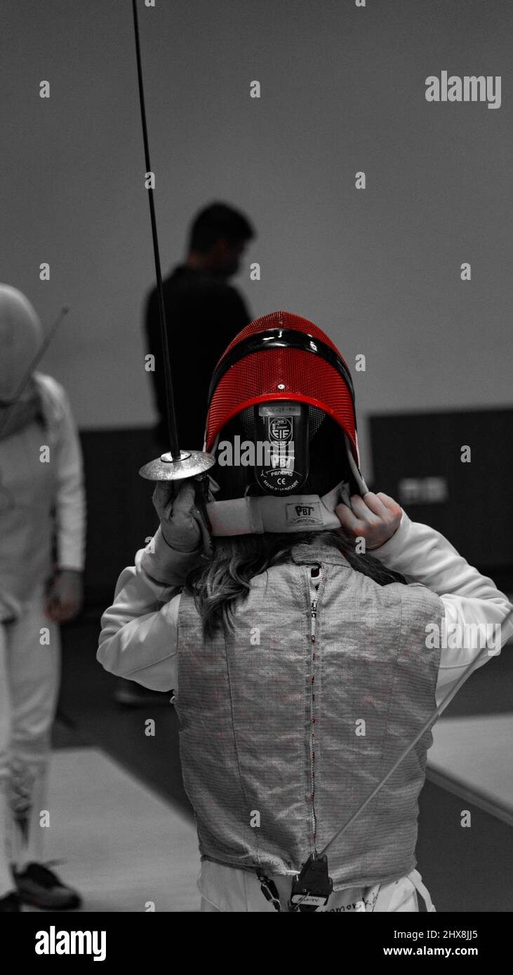 A girl is taking up the fencing mask of PBT Stock Photo - Alamy