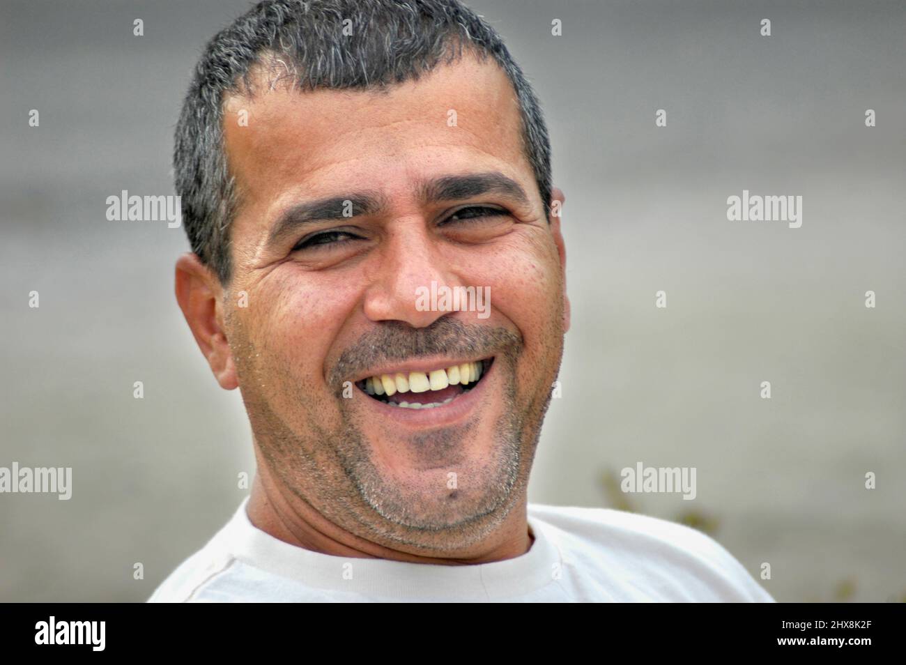 Smiling short haired portrait face of a Middle aged Greek Man in white ...