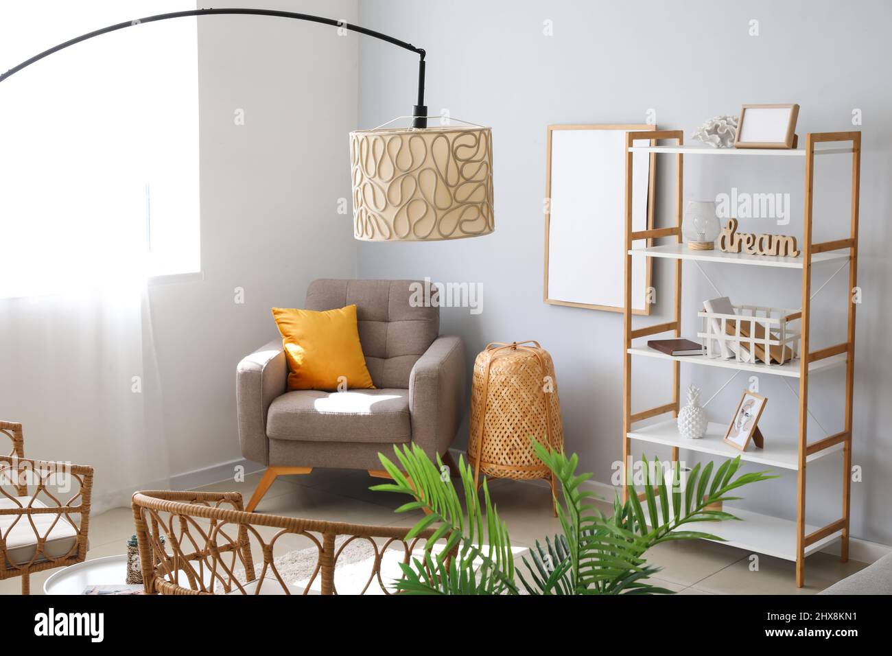Interior of light living room with lamps, chairs and shelving unit ...