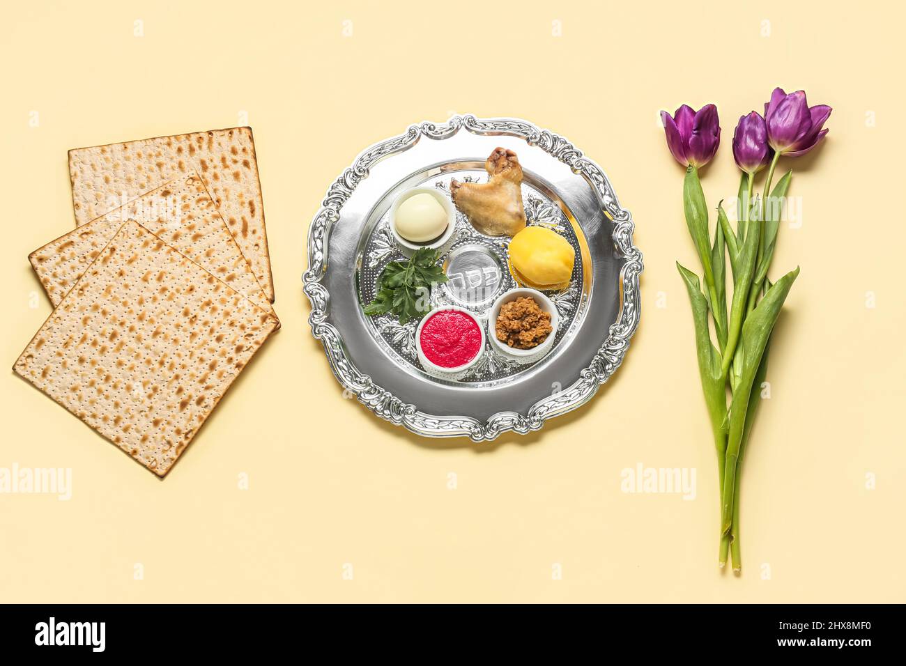 Passover Seder plate with traditional food and tulip flowers on light background Stock Photo - Alamy