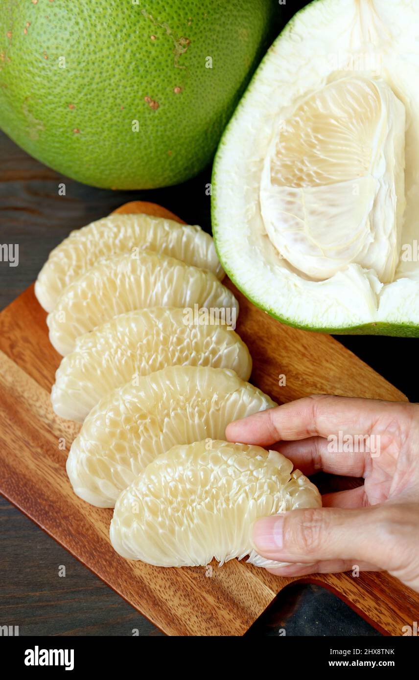 Hand Placing Fresh Pomelo Fruit Segments after Peeled on a Cutting ...