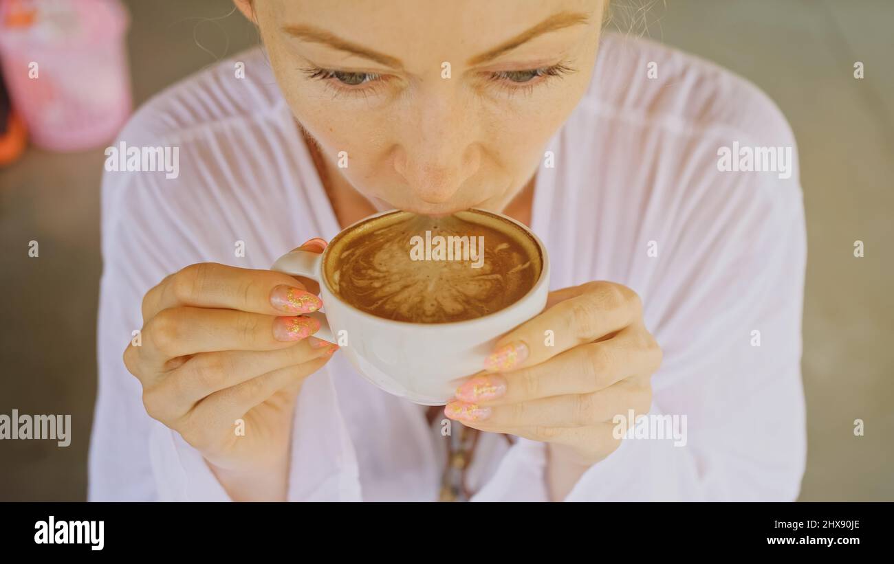 Woman drinking tasty beverages coffee Cappuccino Latte Art. Traveler ...