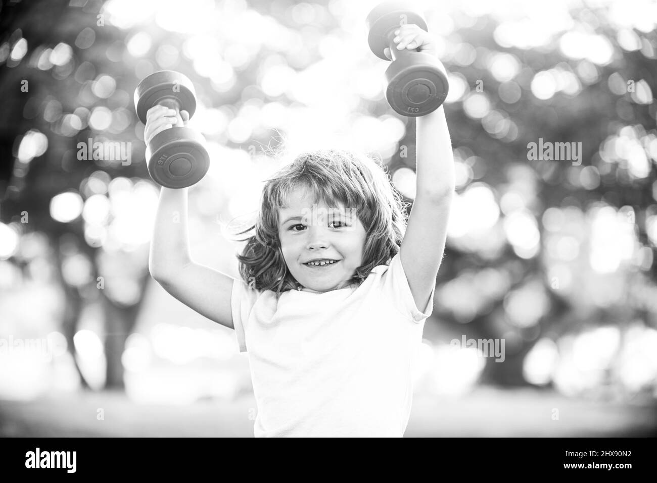 Happy boy workout with dumbbell in park. Sporty activity. Kid sport ...