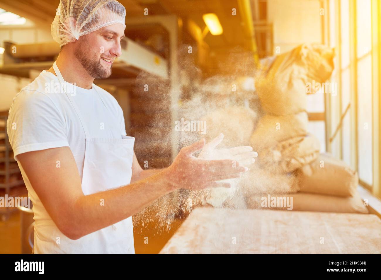 Flour dusts from the baker's hands over the worktop when baking in a ...