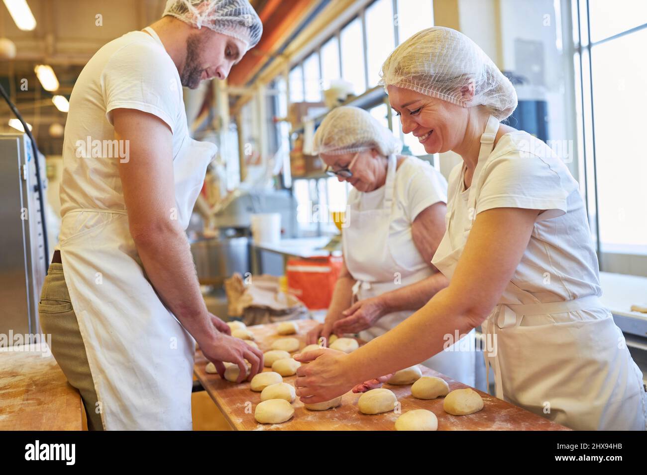 Baker apprentices and older colleagues as a team in the family business ...