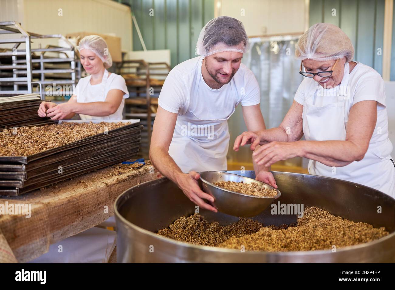 Baker team mix grains for healthy whole wheat bread in big vat in ...