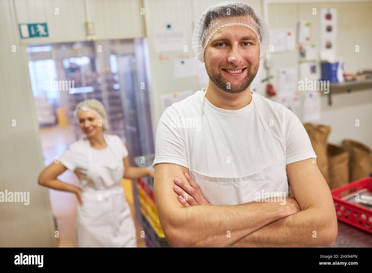 Young man as a proud baker's apprentice with his arms crossed in a ...
