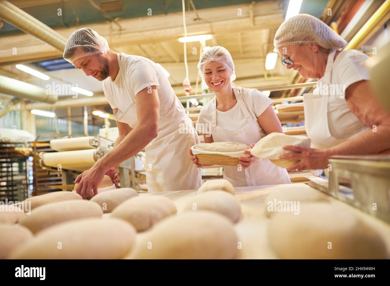 Baker team with apprentices and boss in the family bakery baking bread together Stock Photo - Alamy