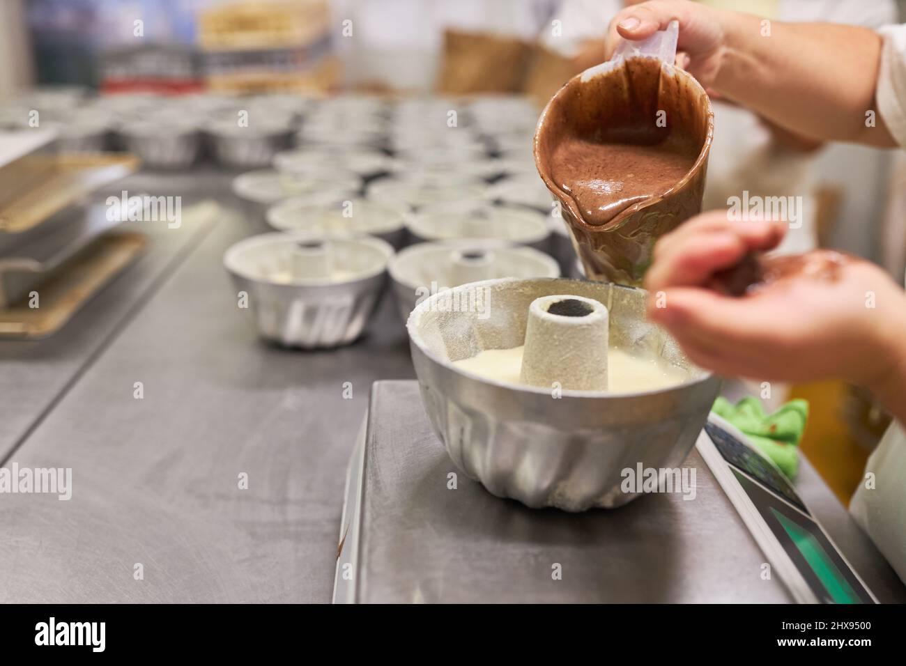 Baker's hands bake Bundt cake and fill cake mold with chocolate and batter in bakery Stock Photo ...