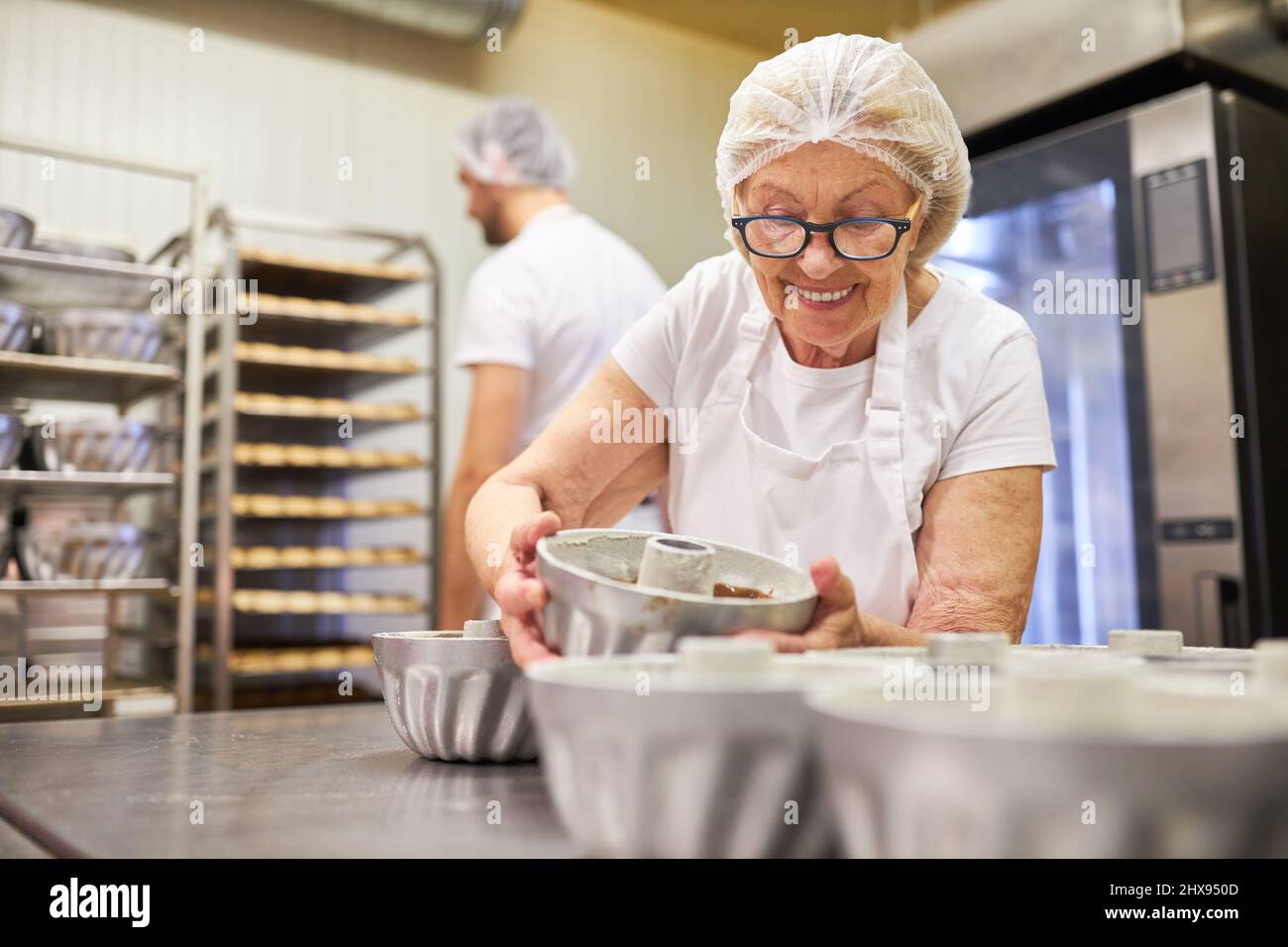 Older woman as a baker with experience in baking Gugelhupf cakes in the ...