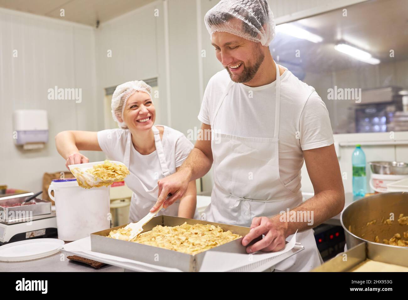 Young baker team baking apple pie in teamwork at bakery in apprenticeship Stock Photo - Alamy