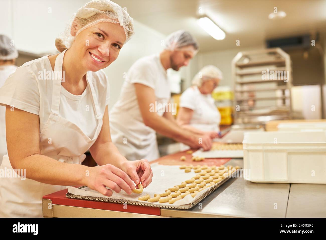Young woman as a baker's apprentice baking vanilla ki Stock Photo - Alamy