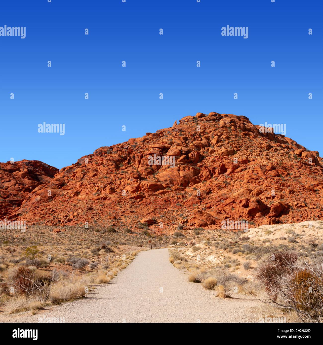 Dirt road in the Red Rock Canyon area with a rocky red hill in Nevada ...