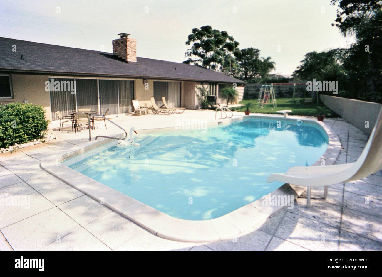 Swimming pool in the back yard of an upper middle class home ca. 1972 ...