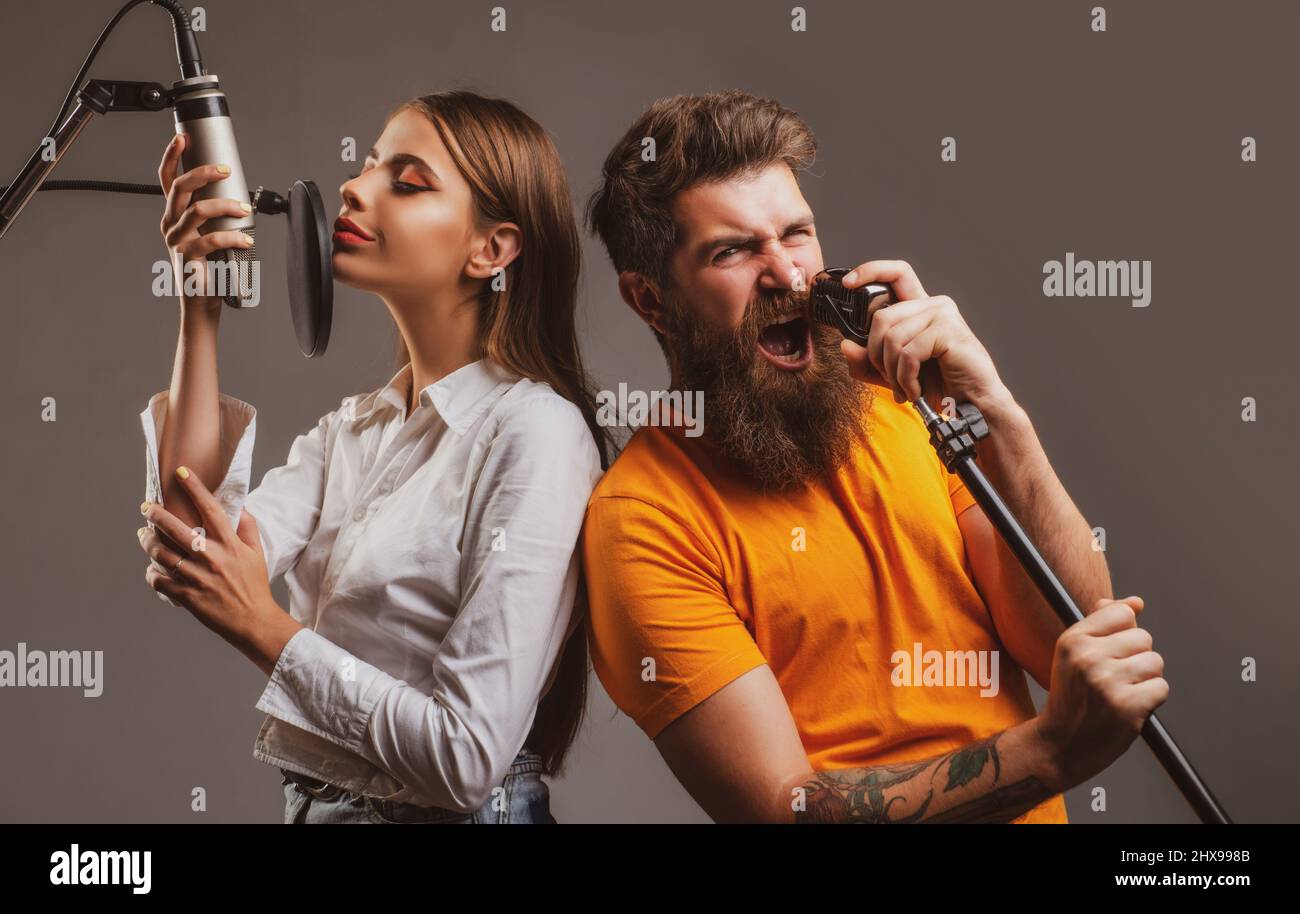 Singing man and young woman in a recording studio. Expressive couple ...