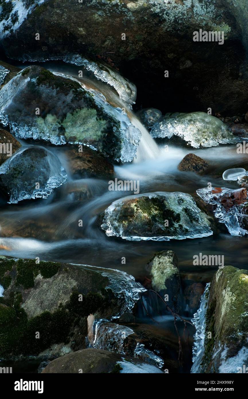 Ice-encrusted boulder in winter stream Stock Photo - Alamy