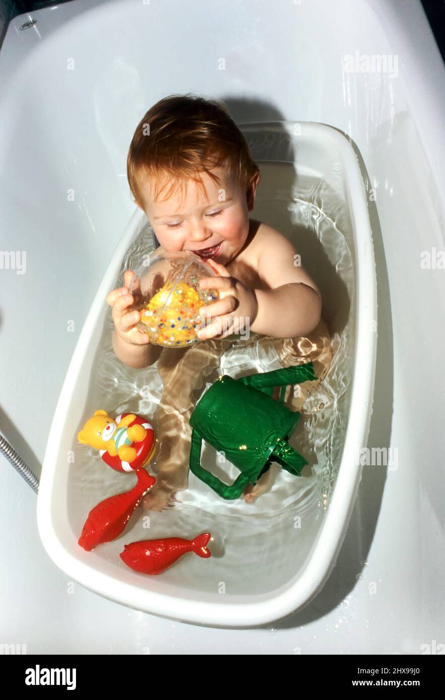 baby in the bath tube with his toys Stock Photo - Alamy