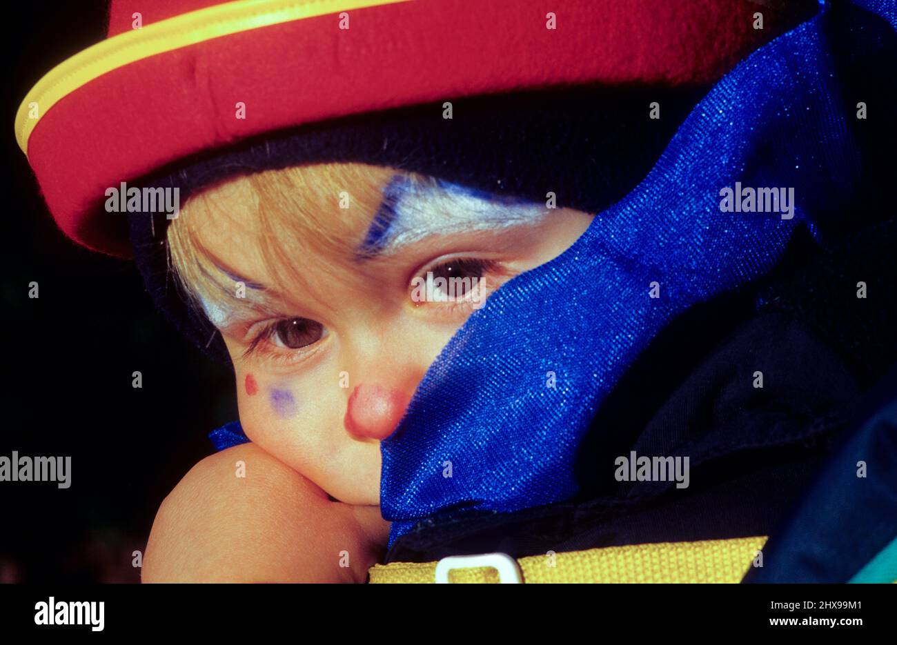 child has a clown maskerade and looks self confident at carneval Stock ...