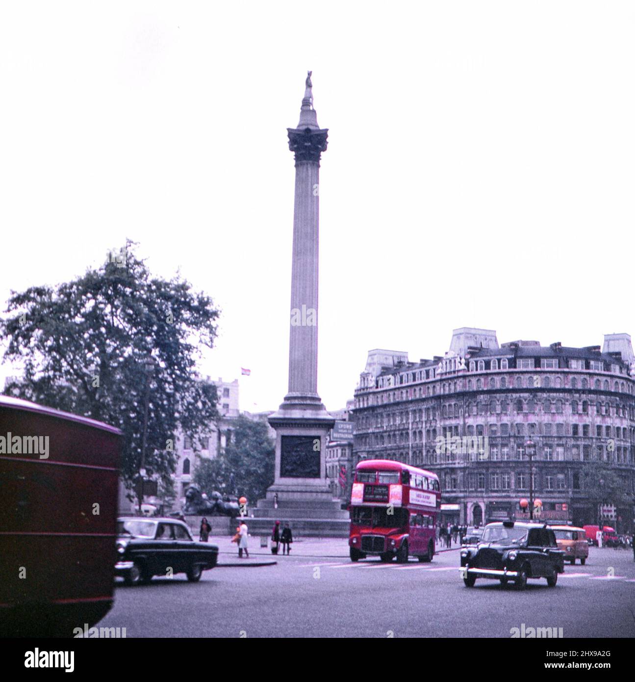 View of Trafalgar Square in London with cars, buses and traffic passing ...
