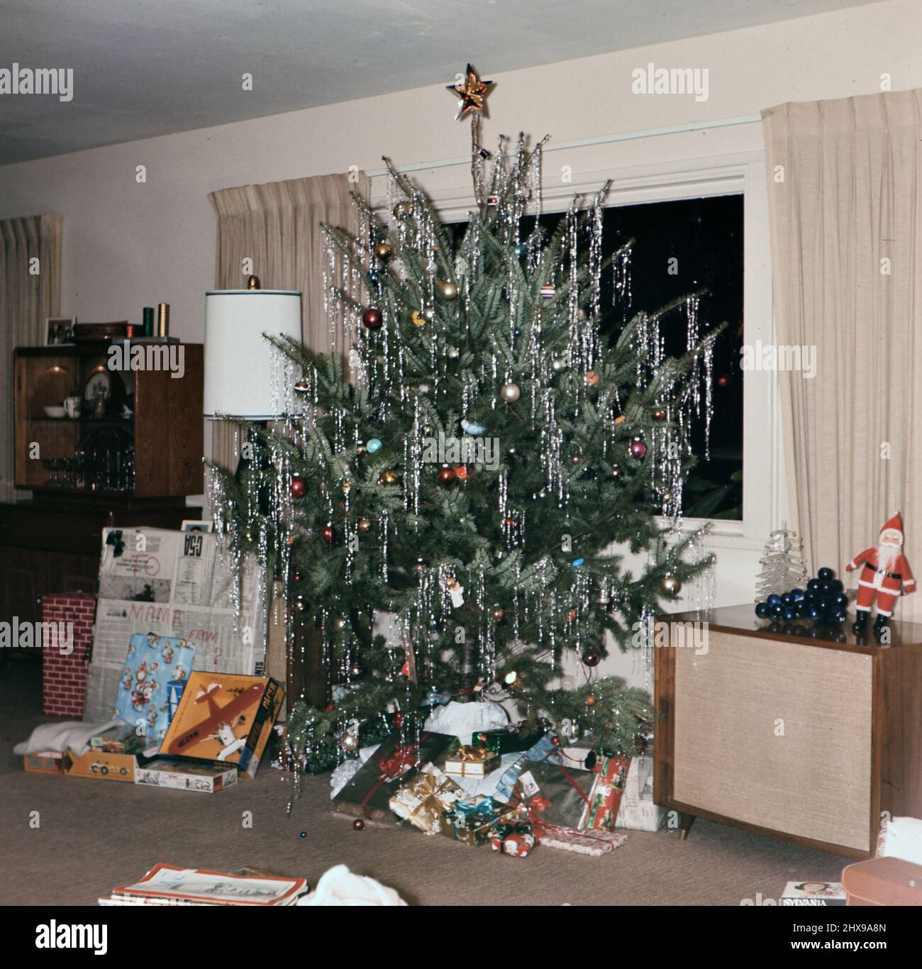 Gifts around a Christmas tree in a living room in the 1960s ca. 1965 ...