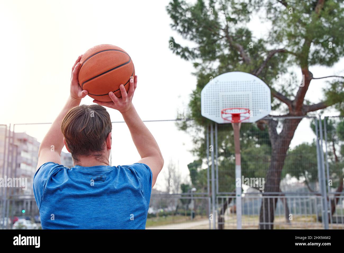 Young player throwing to the basket. Unrecognizable Caucasian man with ...