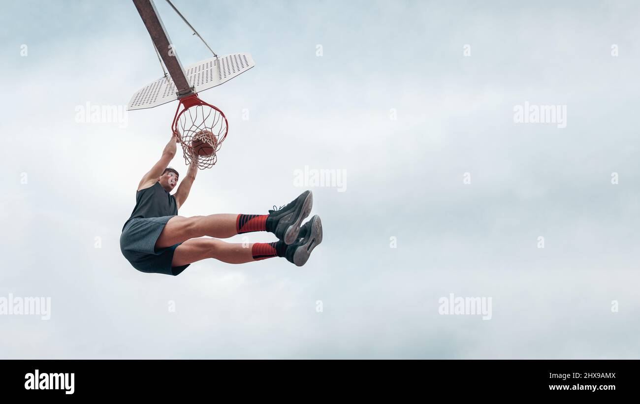 Young Basketball street player making slam dunk Stock Photo - Alamy