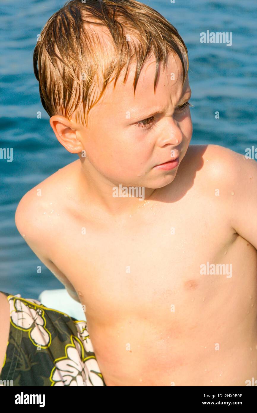 cute boy on a boat is angry and makes a grimace Stock Photo - Alamy