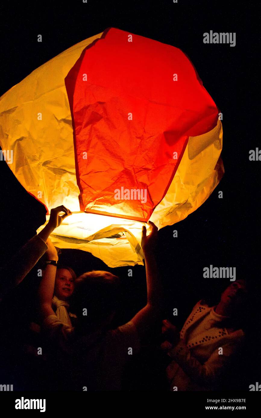 hot air balloon hovering in the air by night Stock Photo - Alamy