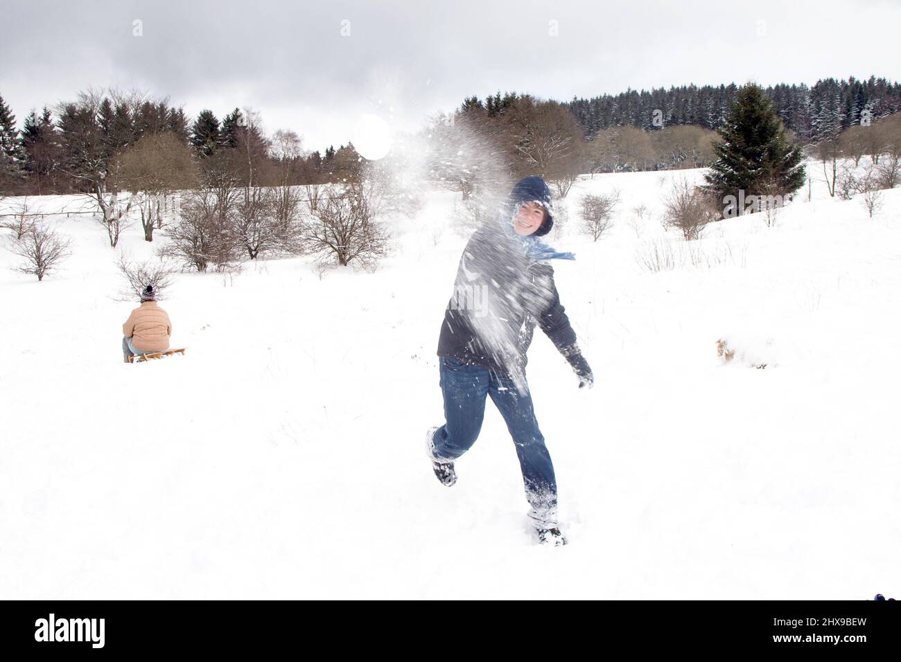 children have a snowball fight in white winter, snow bullet is flying ...