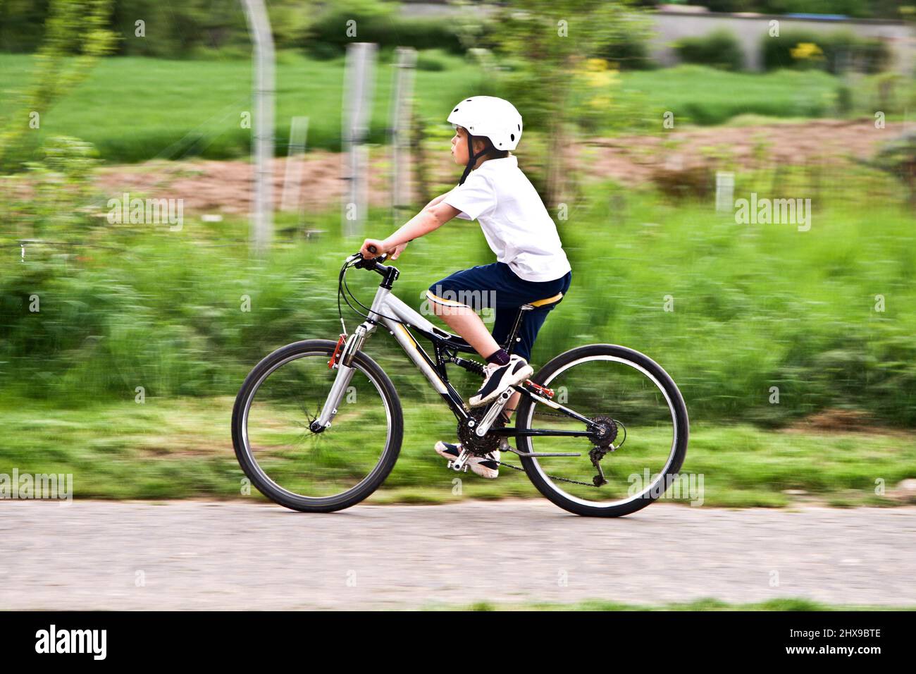 young boy with helmet is riding mountain bike Stock Photo - Alamy