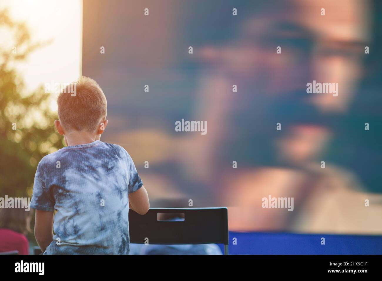 Open-air cinema. Children watching a movie on the screen of a summer ...