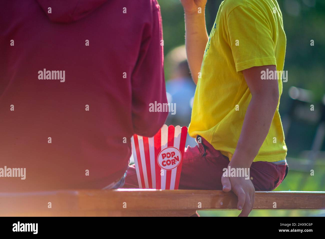 Children holding popcorn while sitting in summer cinema Stock Photo - Alamy